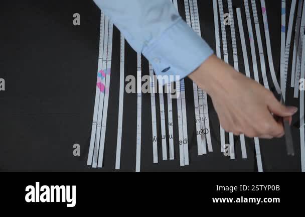 Close up view of Unrecognized hands reassembling shredded document ...