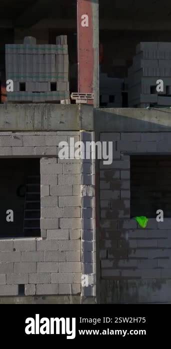 Workers and crane assembling walls. Aerial footage of a detailed and ...