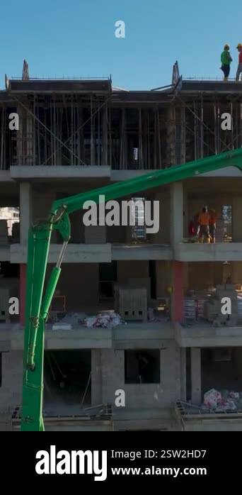 Wall building and crane operations ongoing. Aerial footage of a skilled ...