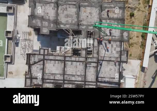 Workers are busy preparing rebar and the floor for future steps on a ...