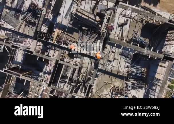 Skilled workers on a busy construction site show progress through their ...