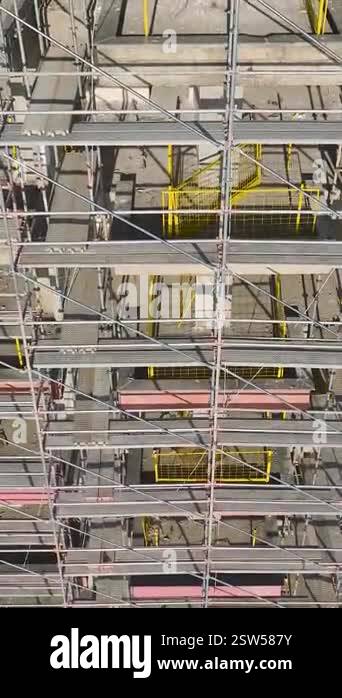 Building frame and scaffolding. Vertical footage of a work-in-progress ...