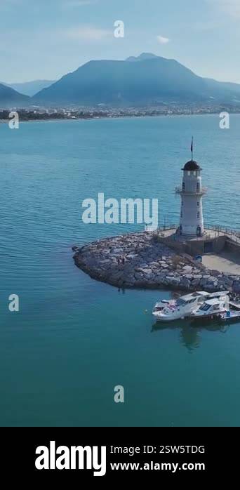 Vertical Video of a Tall White Lighthouse in the Port, Captured From ...