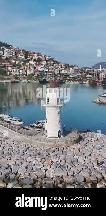 Vertical Video of a Tall White Lighthouse in the Port, Captured From ...