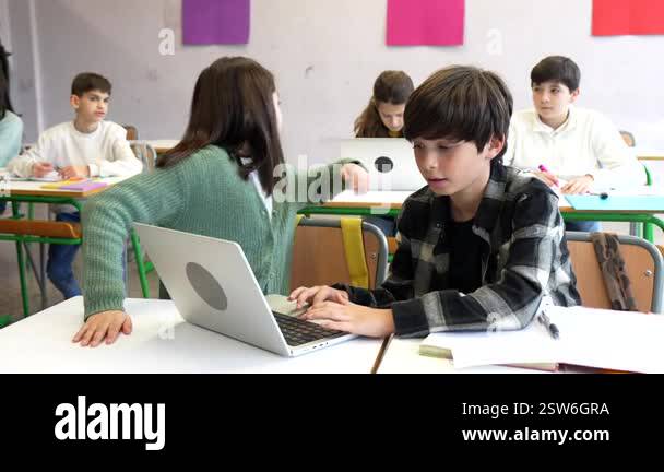 Young students work together on a laptop, demonstrating teamwork and ...