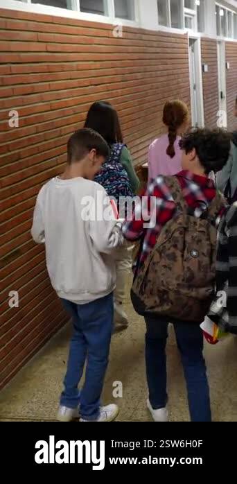Students moving together through school hallway, sharing moment of ...