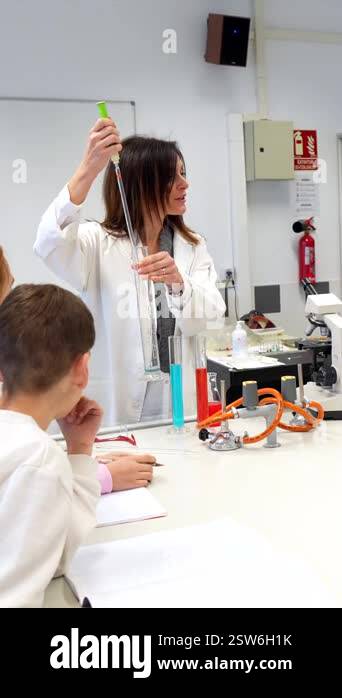 Chemistry educator wearing lab coat performing precise titration experiment, demonstrating ...