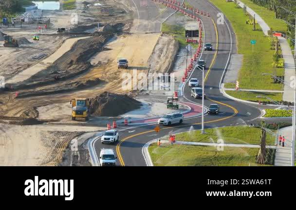 Driving traffic cars at roundabout intersection under construction ...