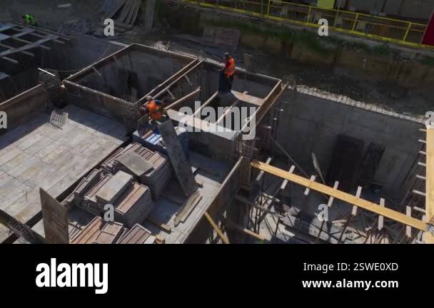 An active construction site with workers and machines building, lifting ...