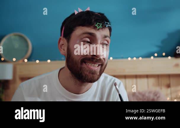 Miserable bored young father squezing a smile looking on camera ...