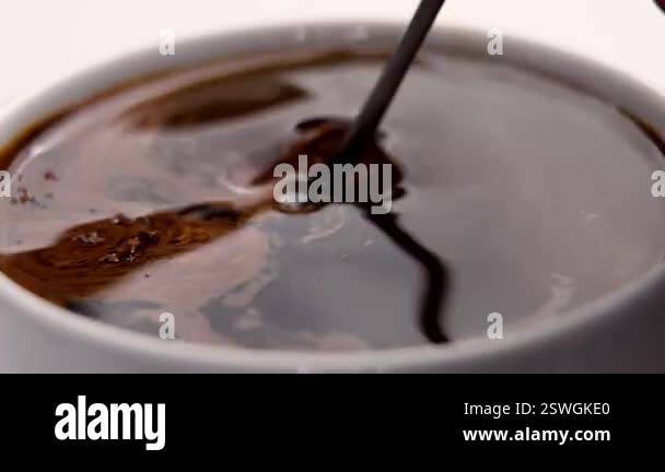 Stirring dissolving instant granulated coffee in white cup with metal ...