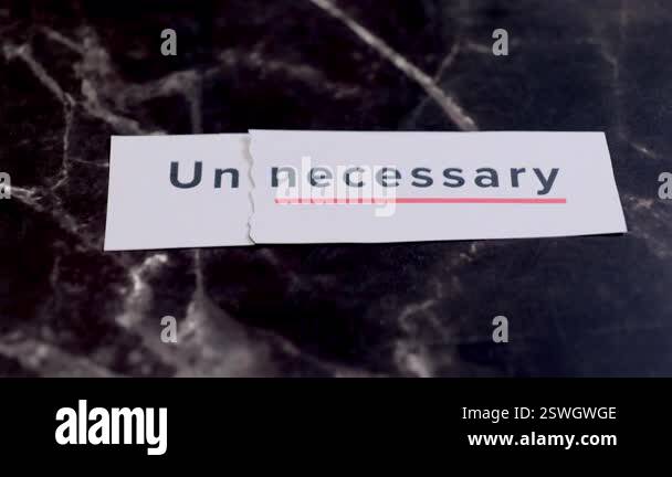A hand points to the torn paper showing the word unnecessary with ...