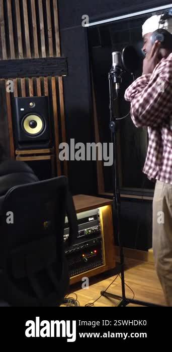 Professional singer wearing headphones, performing vocal recording with ...