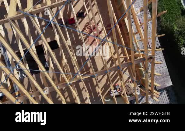 A construction crew is assembling wooden beams at a residential ...