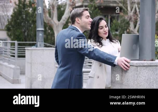 Business partners having a conversation while looking at a laptop ...