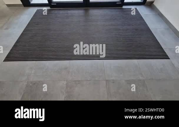 industrial mat cleaning zones at the entrance to the building. A black ...