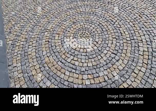stone paving in the square folded into circles with a larger tile in ...