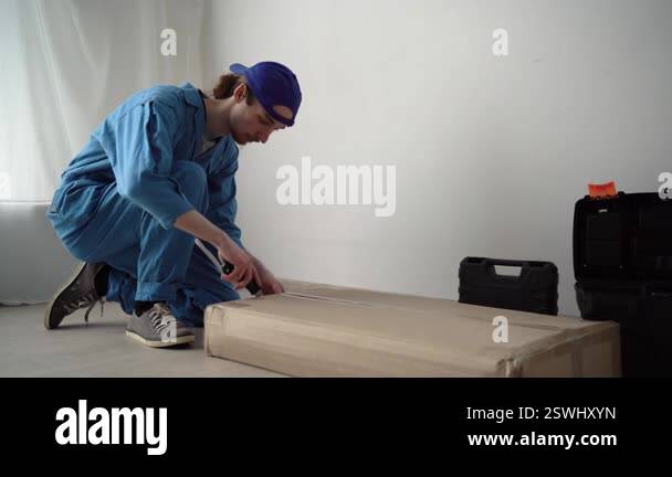 Furniture assembly worker unpacking bookshelf. Young handyman doing ...