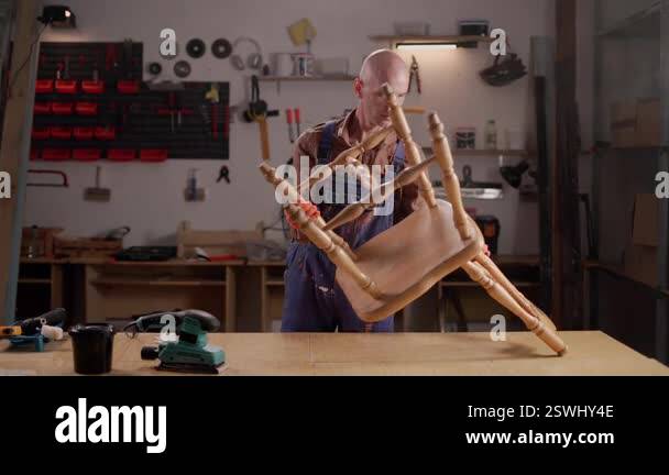 small business concept. Bald man restoring repairing old wooden ...