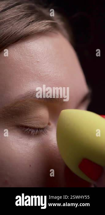 Professional makeup application process, close-up view of closed eye ...
