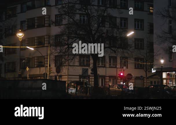 A quiet night scene in Berlin. An illuminated apartment building stands ...