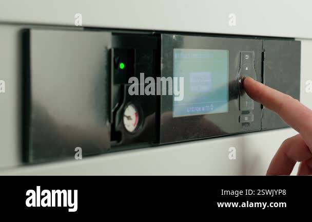 Close-up of person adjusting temperature on heat pump control panel ...