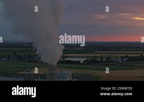 aerial view of two smoking pipes of soviet concrete factory at summer ...