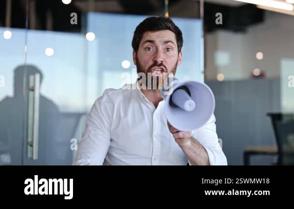 Irritated businessman yells into megaphone in modern office. Aggressive ...