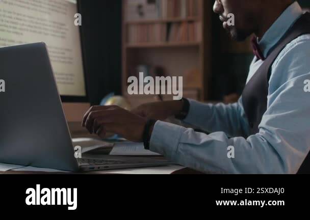 Handheld shot of African American man in glasses, vest and bowtie ...
