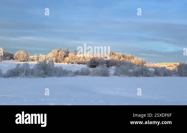 Panning right over a serene snow-covered Nordic landscape during winter ...