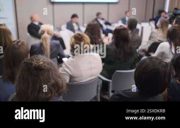 Audience focused on a professional panel discussion on contemporary ...
