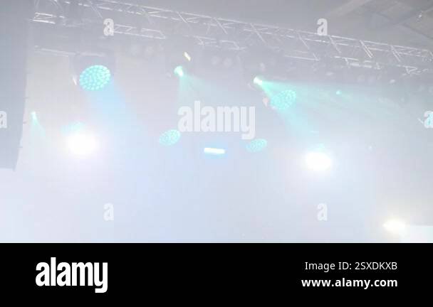 Blue lights projected on stage emit vibrant beams, enhancing intense and vibrant performance ...