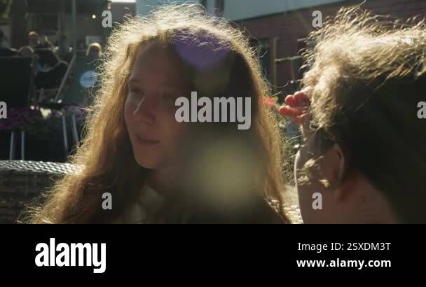 Over shoulder shot two girlfriend talk expressively outdoor with ...