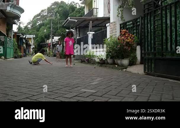 Asian Indonesian children gathered to play cengkleng or Engklek, a ...