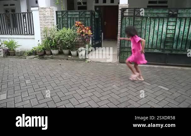 Asian Indonesian children gathered to play cengkleng or Engklek, a ...