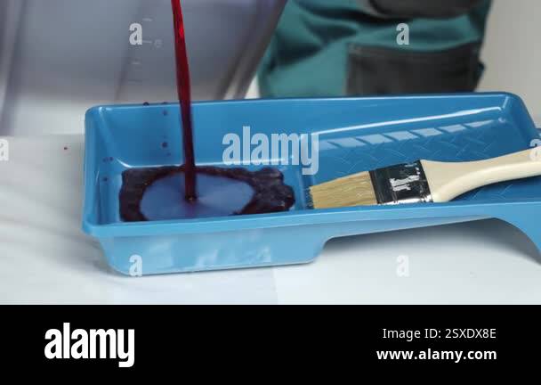 In this vibrant video, a person pours red paint into a blue tray ...