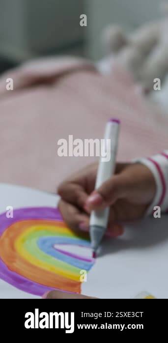 Vertical tilt down shot of concentrated little African American girl ...