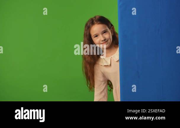 Children emotions concept. Little girl child peeks out and waves hand ...