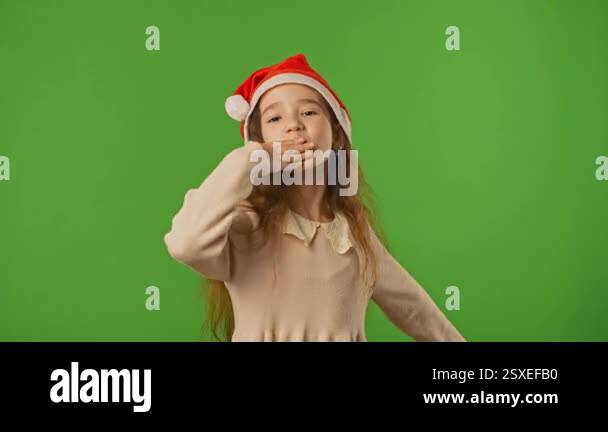 Children emotions concept. Little girl child in santa hat blows an air ...
