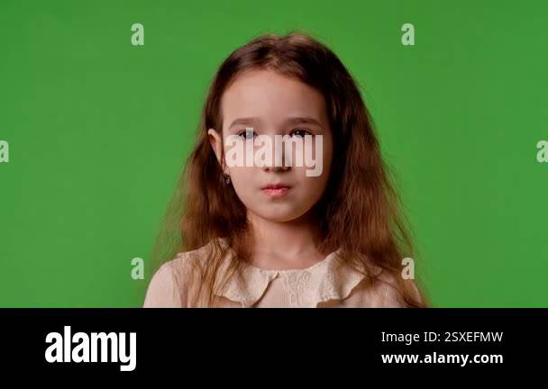 Children emotions concept. Little girl child looks at camera and shows ...