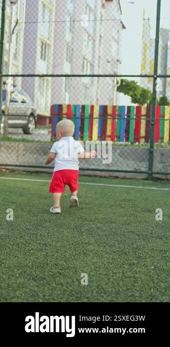 Toddler boy playing on playground in summer under the sun. Child ...