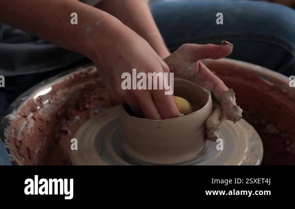 Female artisan sculpts a pottery plate on the spinning wheel 4k video ...