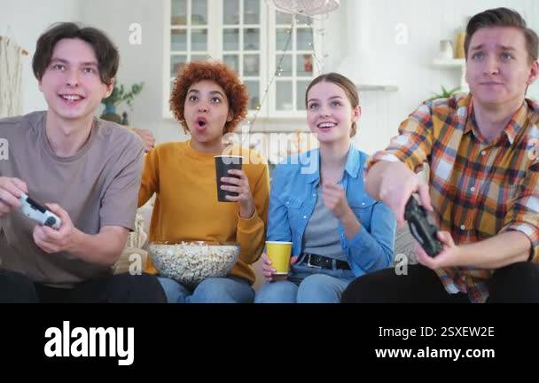 Home party. Cheerful group of friends playing video games at home ...