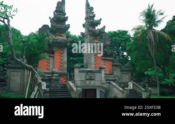A traditional Balinese temple entrance with intricate stone carvings ...