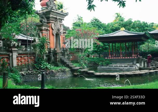 A serene Balinese garden featuring traditional architecture, a pond ...