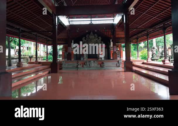 A serene, open temple structure with a polished floor, surrounded by ...