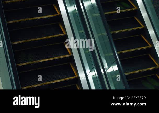 A close-up view of two escalators with shiny metallic surfaces and ...