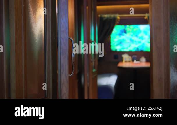 A vintage train compartment with wooden doors slightly open, revealing ...