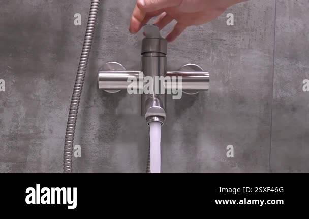 Professional plumber checking water pressure by manipulating chrome ...