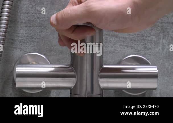 Professional plumber checking water pressure by manipulating chrome ...